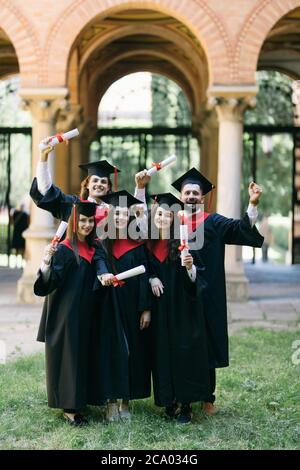 Happy students with diplomas after graduation ceremony outdoors Stock ...