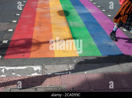 Person walking across a rainbow coloured pedestrian crossing in Camden ...