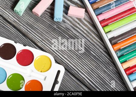 Chalk of different colors, watercolors and pastels for drawing. On ...