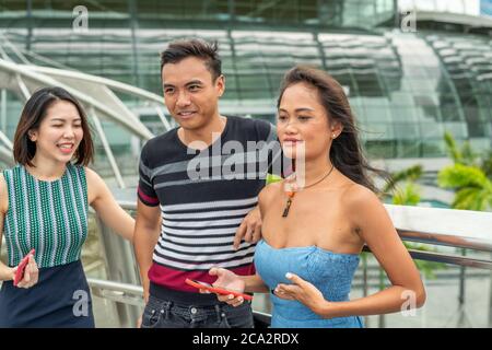 Three asian young friends spending free time outdoor together Stock ...