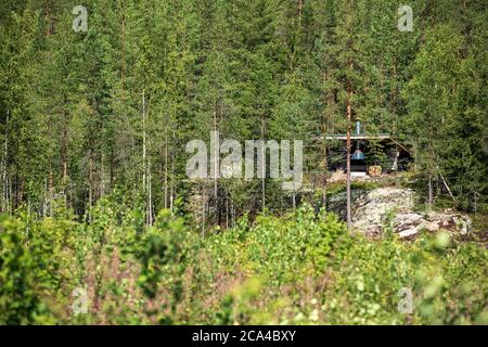 View of a distant wooden lean-to shelter , with fireplace , in the ...