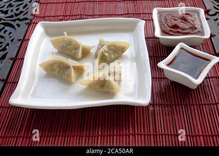VEGETARIAN DIM SUM UNCOOKED WITH CHILLI OIL AND SCHEZWAN SAUCE Stock ...