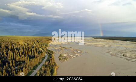 A big wide muddy river flows off Glaciers of the Denali Range towards ...