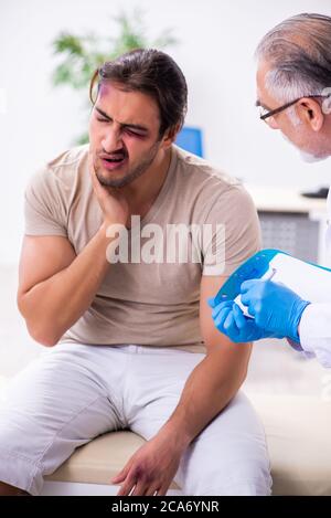 Young face injured man visiting experienced male doctor traumatologist ...