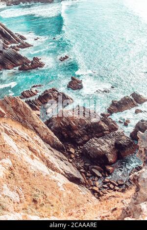 Rocks at bottom of cliff by ocean Stock Photo - Alamy