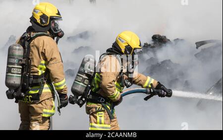 Firefighter spray water on fire with hose Stock Photo - Alamy