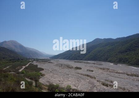 Wide river with a very strong stream surrounded by hills Stock Photo ...