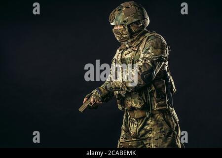 fearless brave strong man with gun isolated in black space, in ...