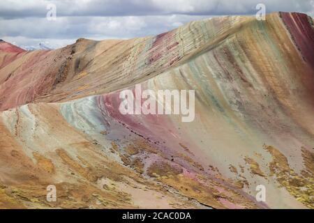Beautiful Palcoyo rainbow mountains in Cusco, Peru under a cloudy blue ...
