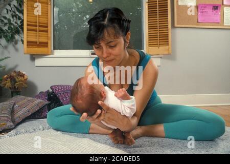 Austin, Texas USA, 1993: New mom in exercise attire looking into eyes ...