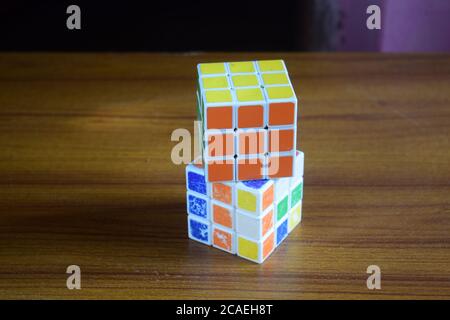 High angle view of a solved Rubik's cube on a wooden table under the lights Stock Photo - Alamy