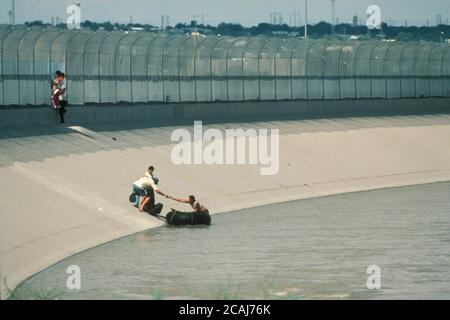 Group of immigrants cross the channelized Rio Grande River, the ...