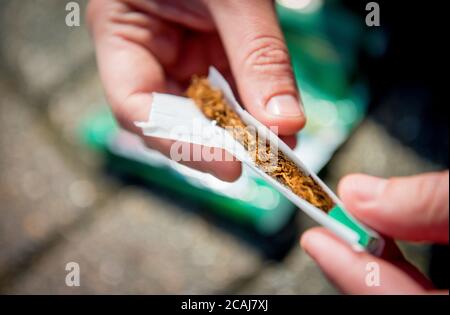 A smoker making a hand rolled cigarette Stock Photo - Alamy