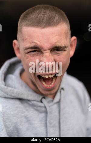 A bully guy in a light sports jacket with a hood Stock Photo - Alamy