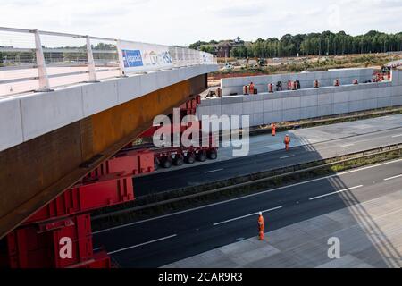 HS2 workers watch as a bridge is wheeled into position over the M42 at ...
