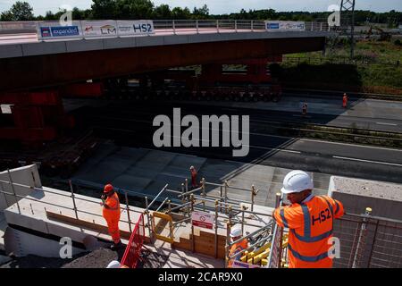 HS2 workers watch as a bridge is wheeled into position over the M42 at ...
