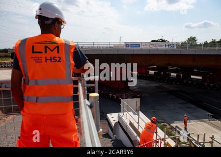 HS2 workers watch as a bridge is wheeled into position over the M42 at ...