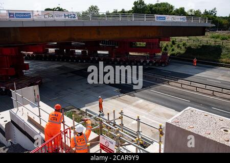 HS2 workers watch as a bridge is wheeled into position over the M42 at ...