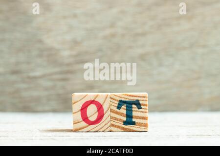 Alphabet letter in word OT (abbreviation for overtime) on wood ...