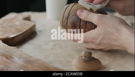 woodworker applying oil finish to olive wood scoop Stock Photo - Alamy