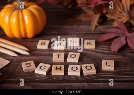 School supplies, pumpkin, autumn leaves and text back to school on the ...