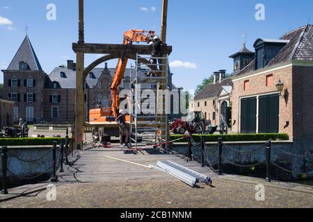 Construction workers with mobile crane and grab repair the wooden ...
