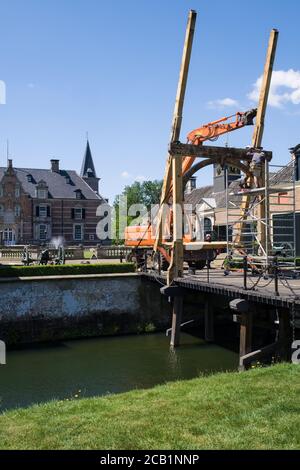 Construction workers with mobile crane and grab repair the wooden ...