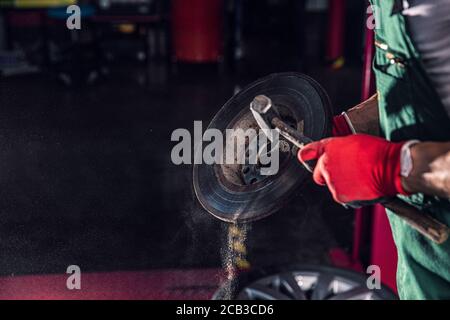 Professional mechanic man hammering the rusty car bearing Stock Photo ...