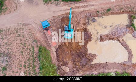 Backhoe loading soil into a truck then the truck carries soil for sale ...