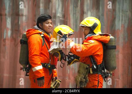 The portrait of Asian firefighters are wearing orange fire protection ...