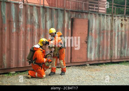 The portrait of Asian firefighters are wearing orange fire protection ...