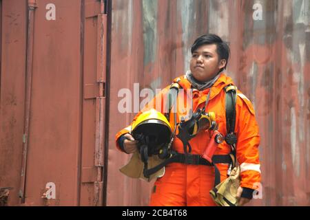 The portrait of young Asian firefighters are wearing orange fire ...