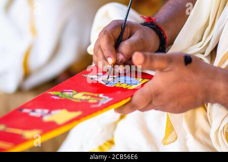 The Ceremonial bow, Onavillu. Artisan painting god's pictures on bow ...