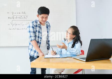 Smiling math tutor explaining difficult topic to student during online ...