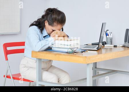 Portrait of a female teacher leaning on a desk in a classroom Stock ...