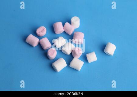 Closeup shot of pink and blue marshmallows in a cute pink cup and on ...