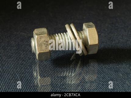 The Bolt with thread by nut and puck on table with reflection.Detail ...