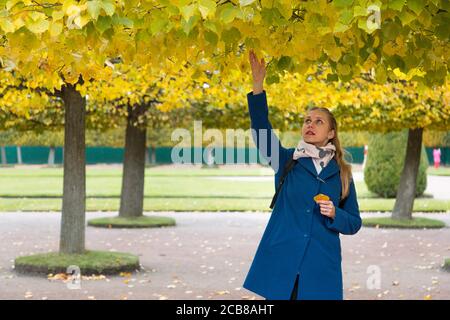 Lady in light blue coat walks down the entrance path towards the ...