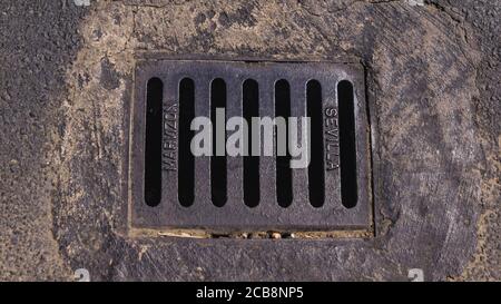 iron canal cover between the concrete pavement Stock Photo - Alamy