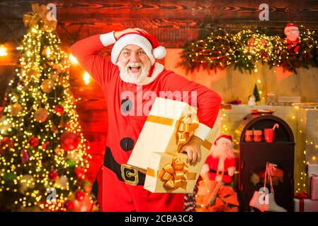 New year. Joyful grandpa with gift. Dreamy grandfather in Santa hat ...