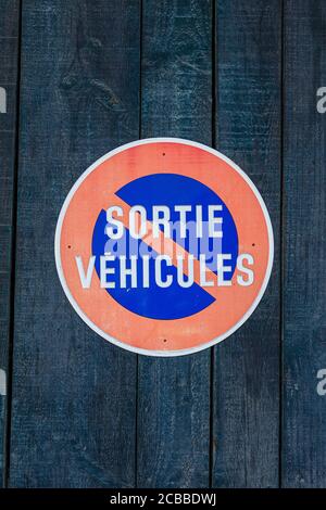 French 'Vehicle Exit' and 'No Parking' signs on a garage door in a ...