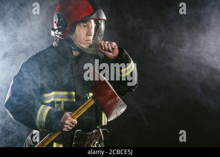 strong middle-aged fireman going to save and protect people from fire ...