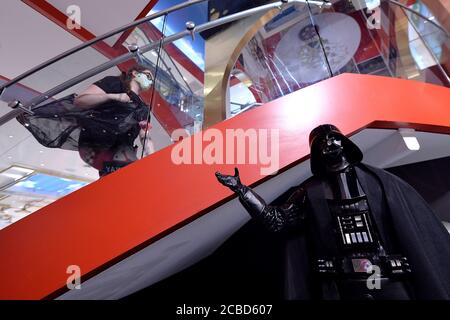 A shopper walks up stairs past a Darth Vader figurine at the newly ...