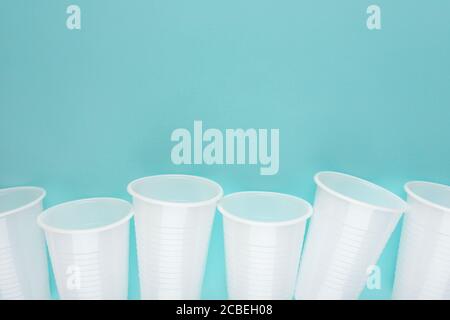 White plastic empty cups laid out in a row on blue background Stock ...