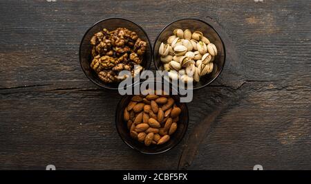 Almond and walnut in a small plates which standing on a wooden vintage ...