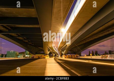 Under a large bridge at night, a massive bridge construction at night ...