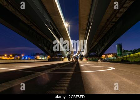 Under a large bridge at night, a massive bridge construction at night ...
