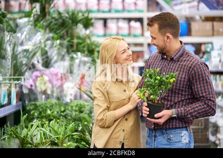 Portrait of woman choosing pots for flowers in gardening market Stock ...