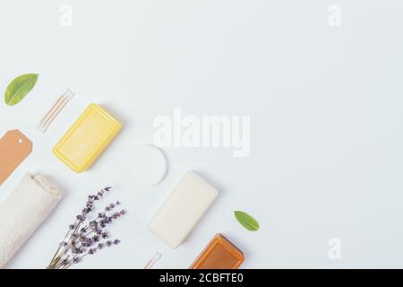 Soaps, herbs and terry towel on white background, flat lay composition ...