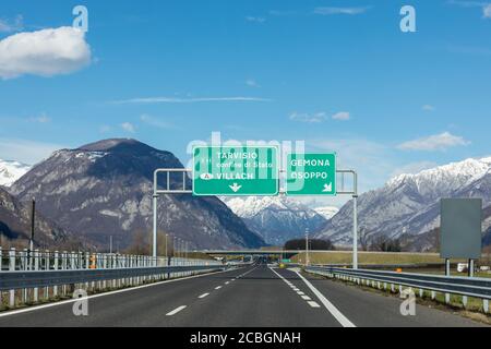 Road sign on Italian motorway (autostrada) A23 showing directions to ...